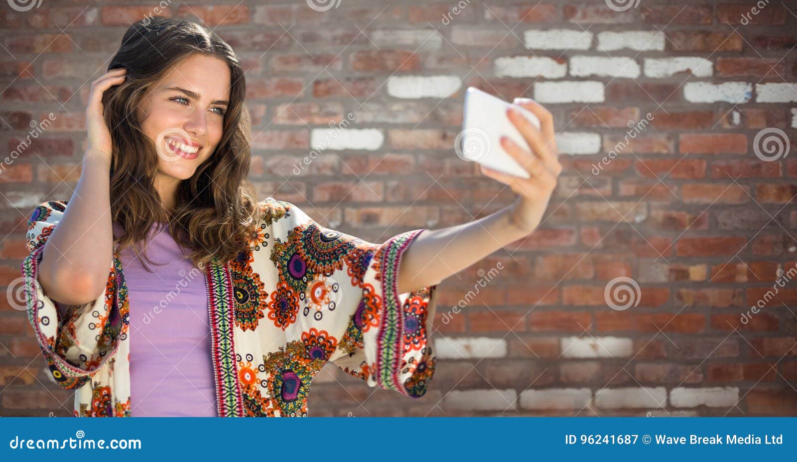 Millennial Girl Taking Selfie Against Red Brick Wall Stock Image
