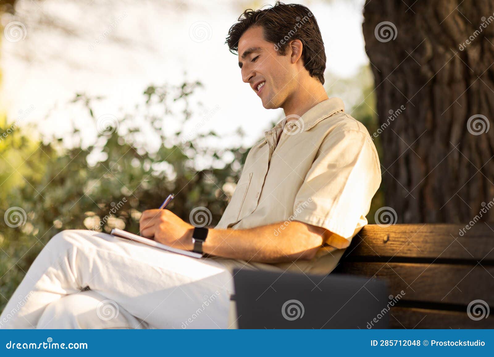 Millennial Man Student Sitting on Bench, Doing Homework Stock Photo ...