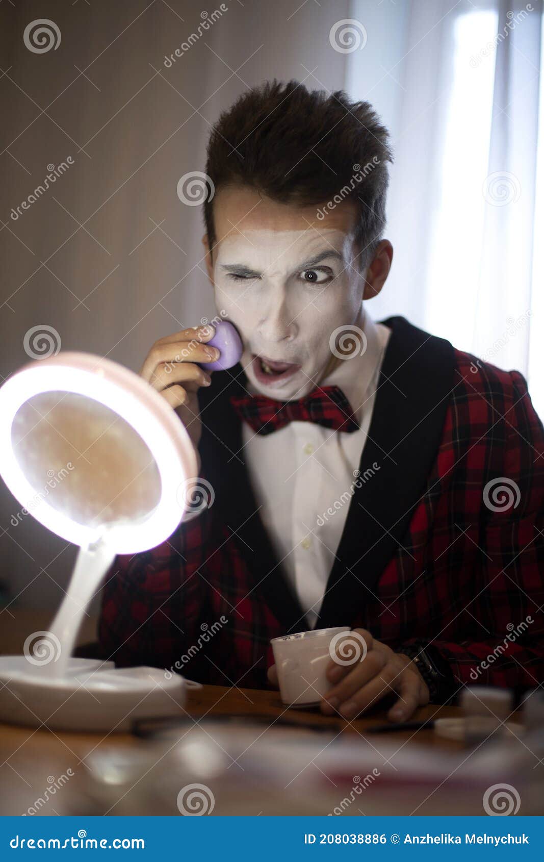 Mime Puts on Makeup in Front of the Mirror and Makes Faces Stock Photo ...