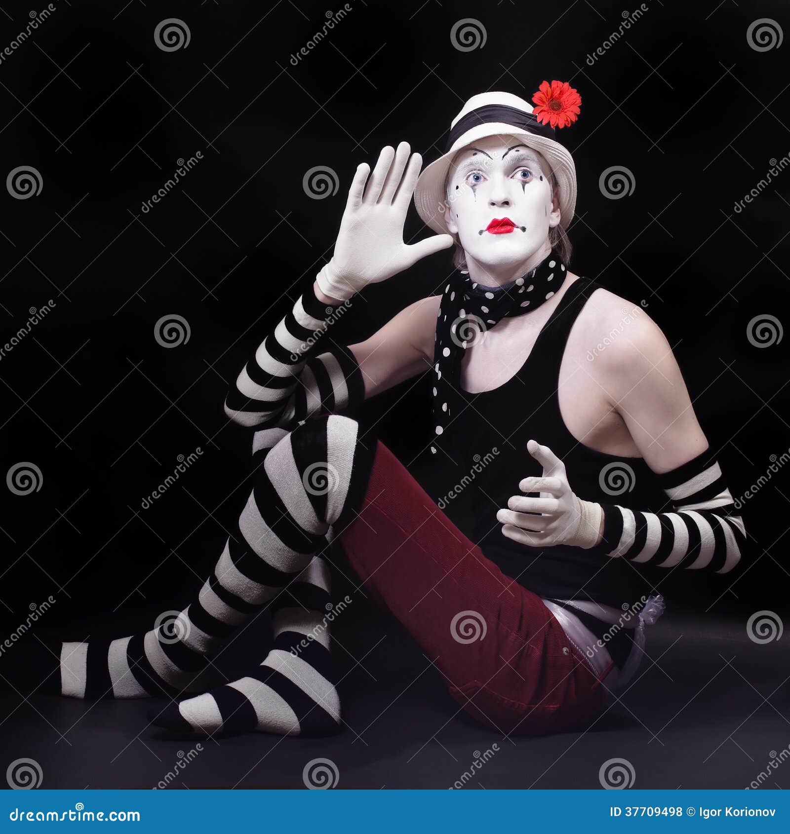 Mime in White Hat with Red Flower Sits on the Floor Stock Photo - Image ...
