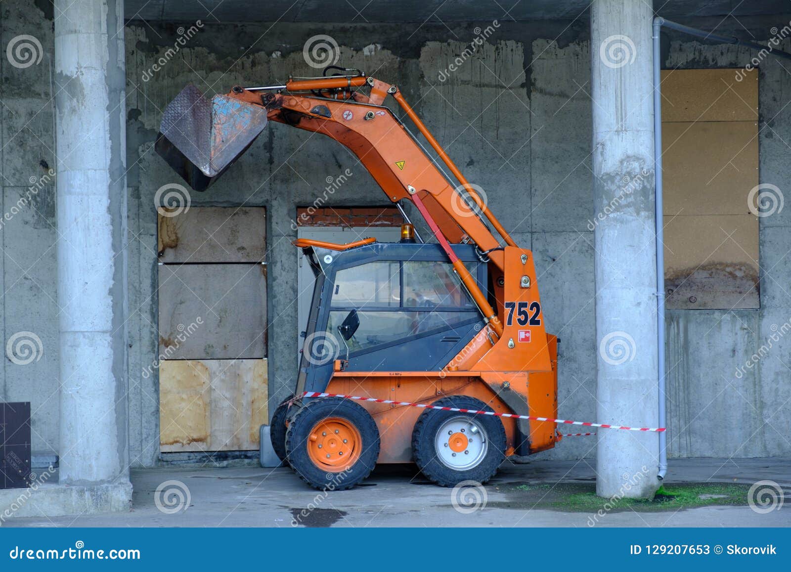 Mini Backhoe Loader Stands with a Raised Bucket. Bucket Excavator of ...