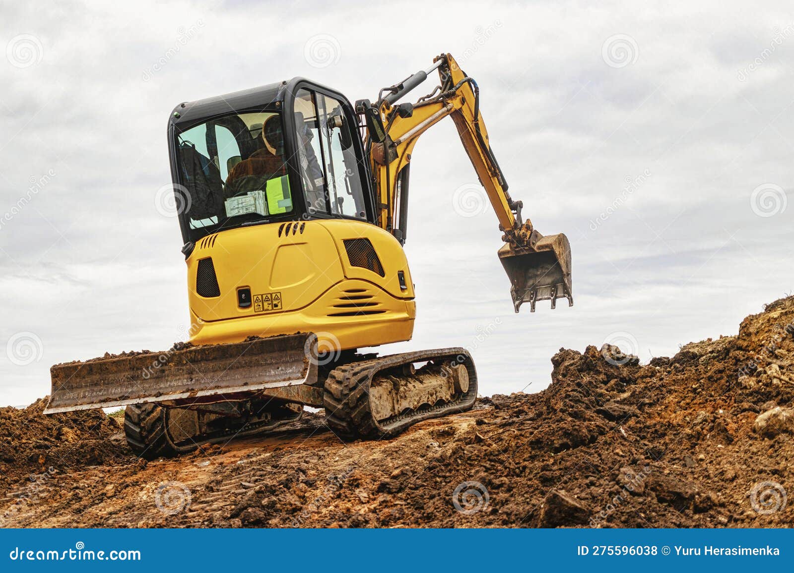 Mini Excavator at the Construction Site on the Edge of a Pit Against a ...
