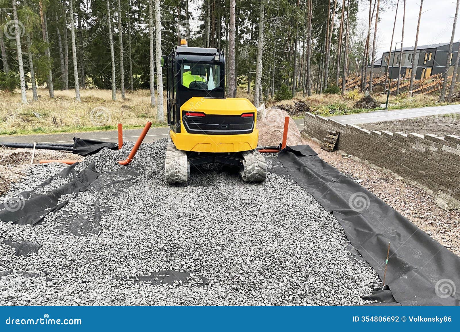 Mini Excavator Levels Crushed Stone during the Construction of a House ...