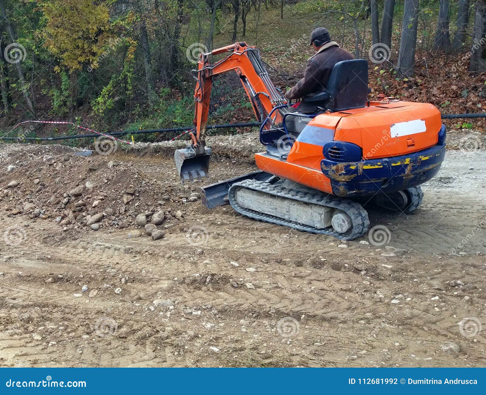 Mini excavator and worker editorial photography. Image of operator ...