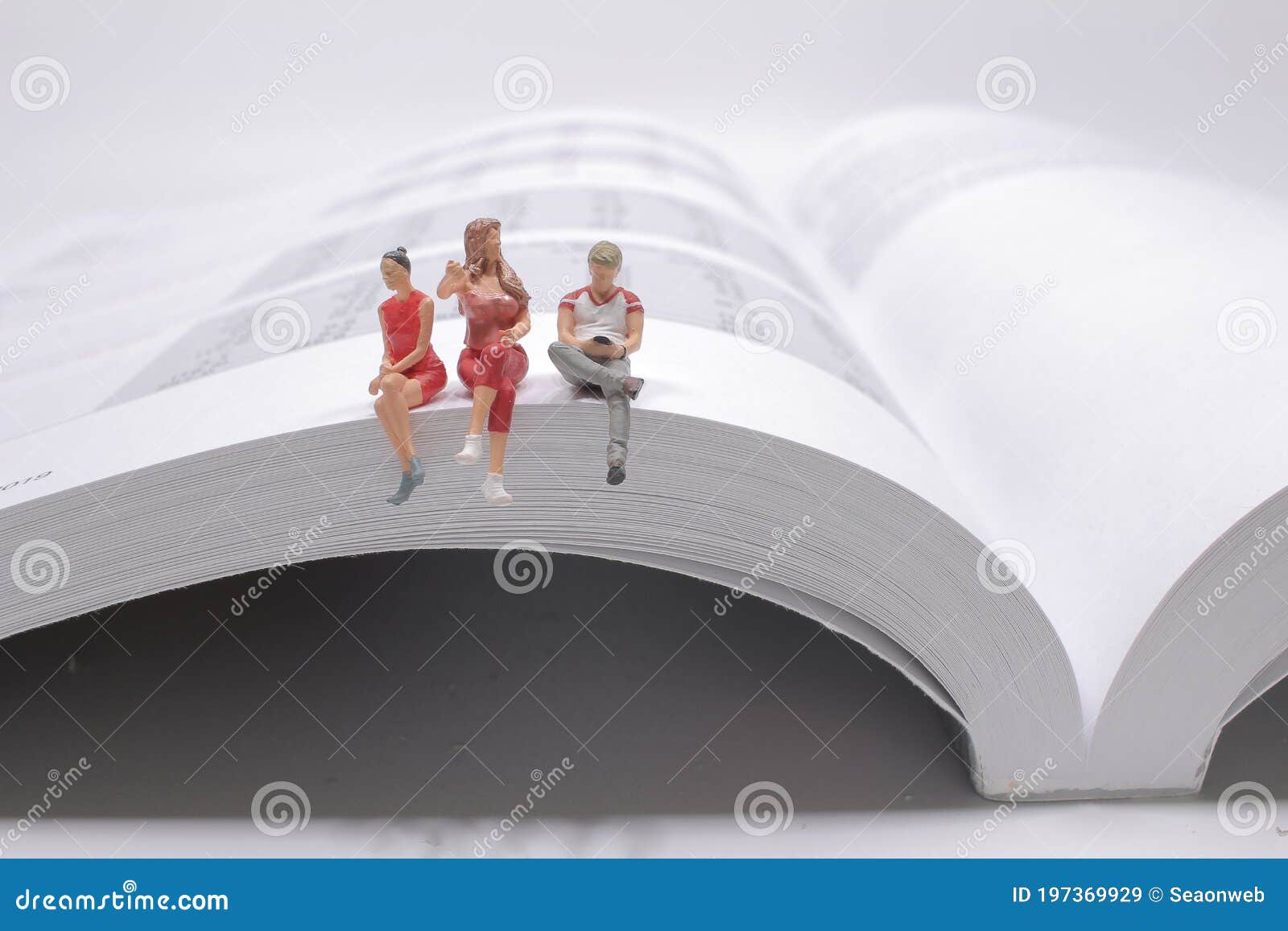 Mini Figure Reading Newspaper and Sitting on Book Stock Image - Image ...