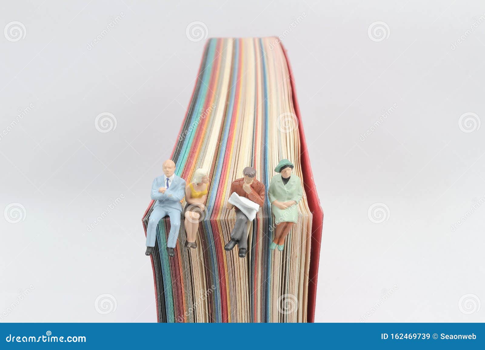 A Mini Figure Reading and Sitting on Book Stock Image - Image of book ...