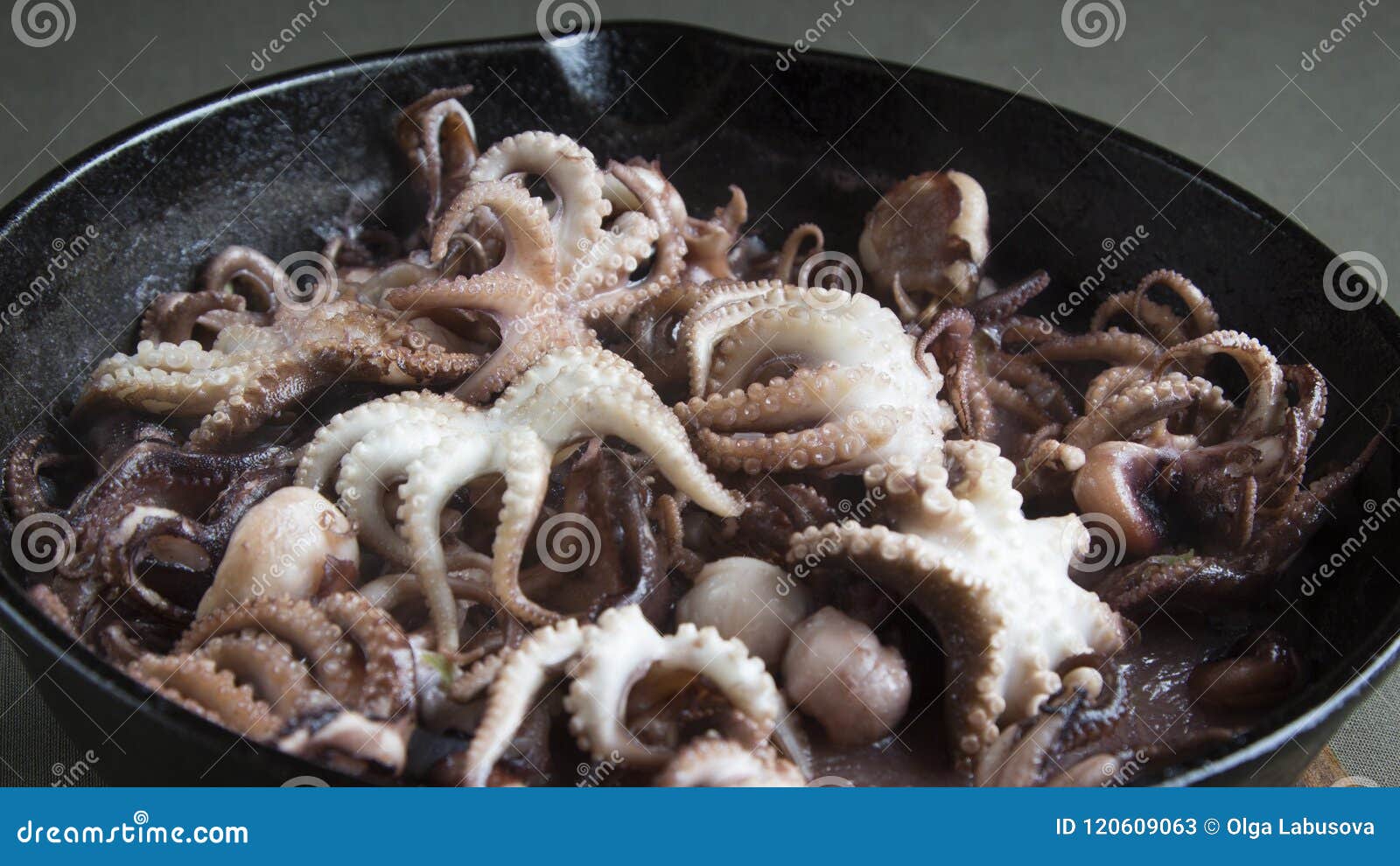 Mini Octopus In The Process Of Roasting On A Cast Iron Pan Royalty-Free ...