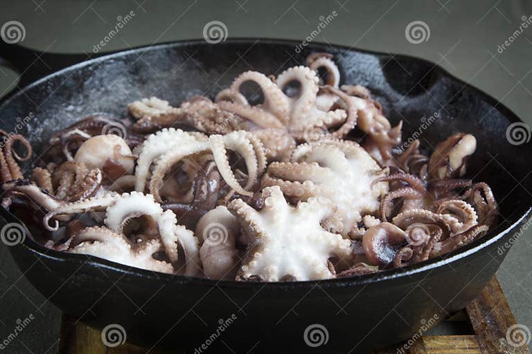 Mini Octopus in the Process of Roasting on a Cast Iron Pan Stock Photo ...