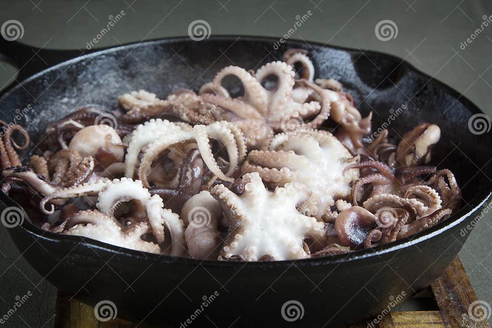 Mini Octopus in the Process of Roasting on a Cast Iron Pan Stock Photo ...