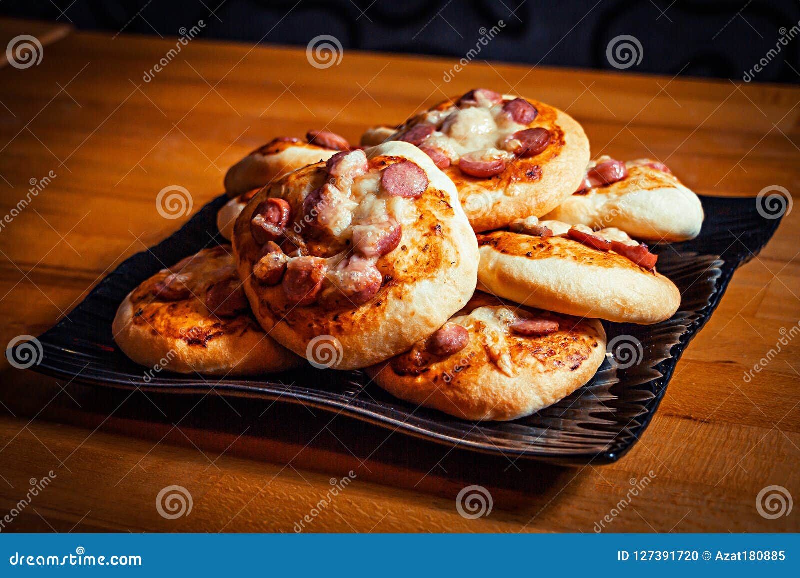 Mini Pizza in Black Stylish Ware on a Wooden Table. Stock Photo - Image ...