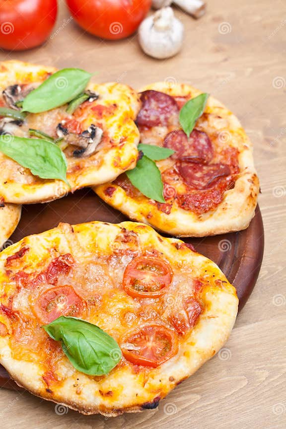 Mini Pizzas on a Cutting Board and Ingredients Stock Image - Image of ...