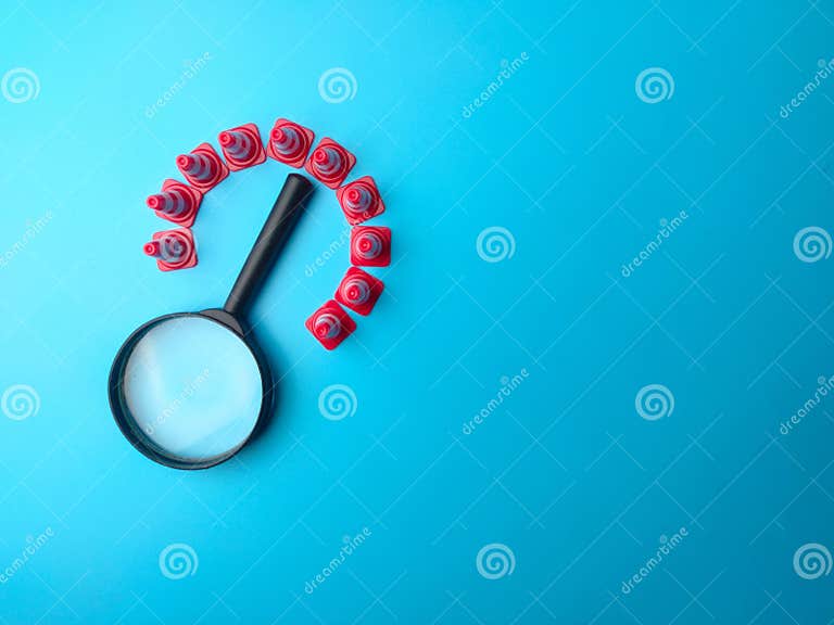 Mini Plastic Cones and Magnifying Glass on a Blue Background Stock ...