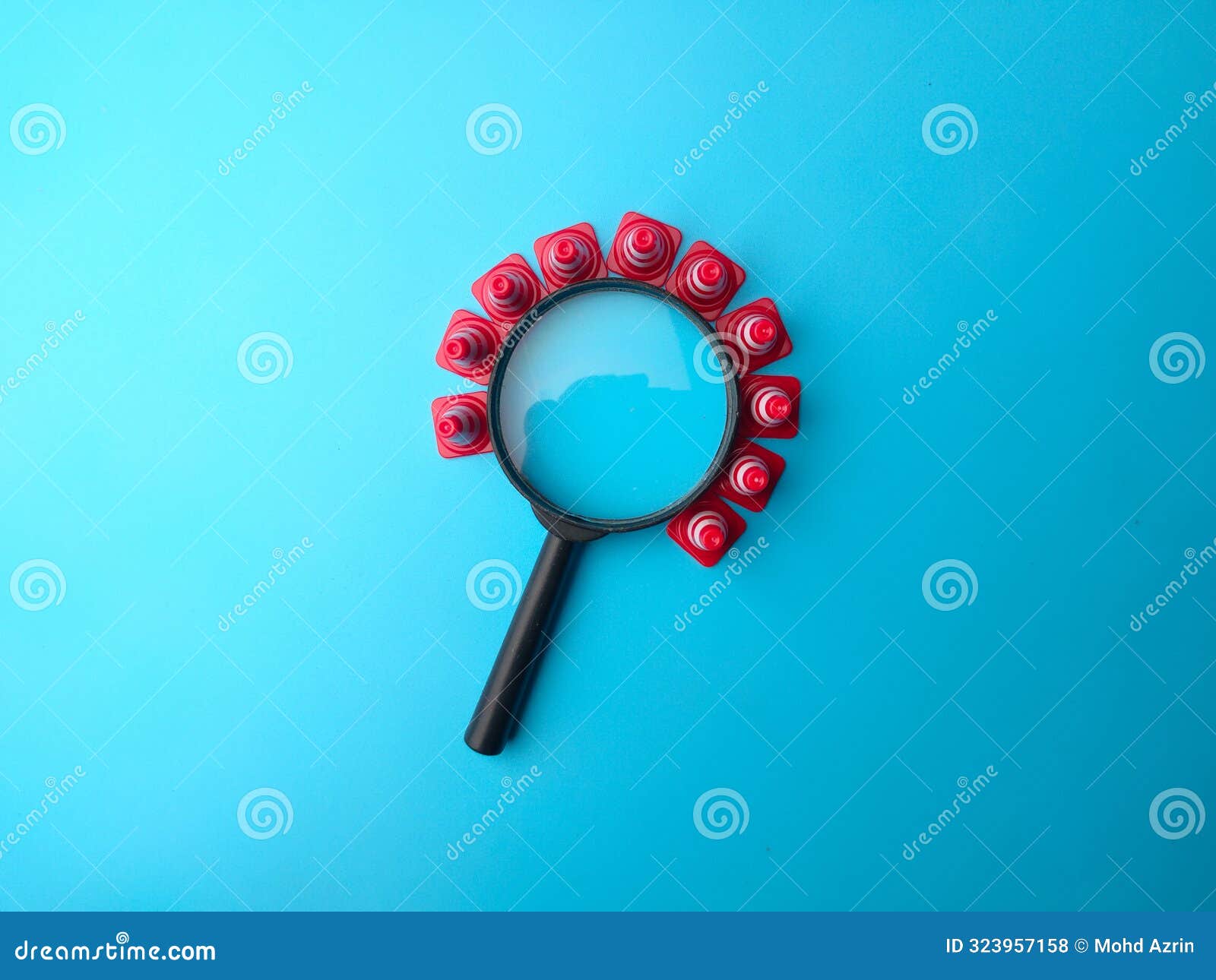 Mini Plastic Cones and Magnifying Glass on a Blue Background Stock ...