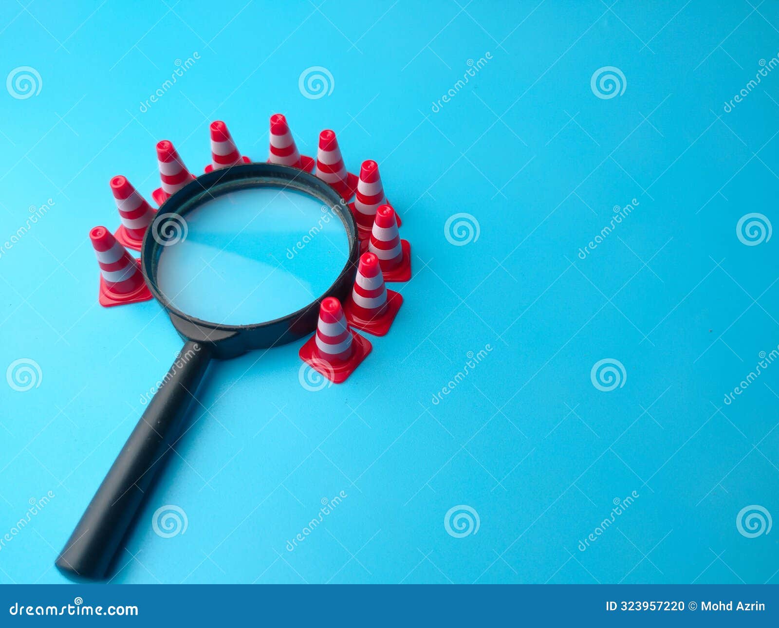 Mini Plastic Cones and Magnifying Glass on a Blue Background Stock ...