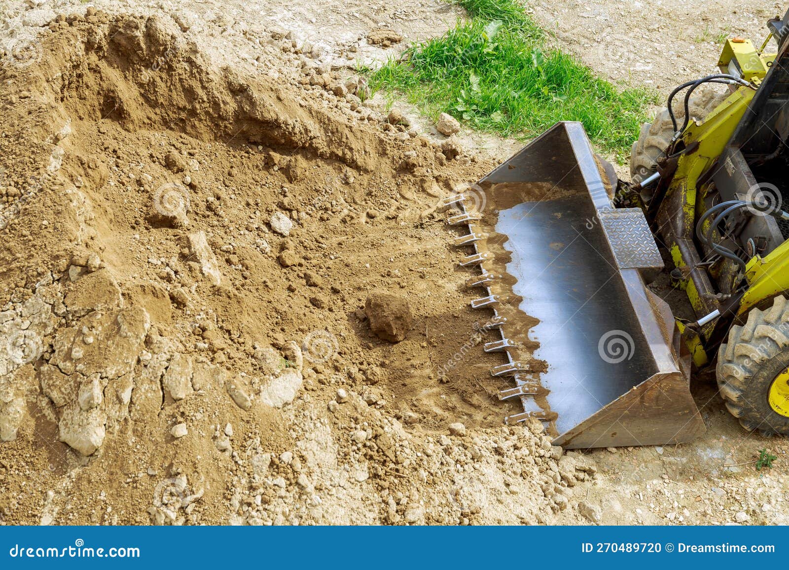 A Mini Tractor-loader Moves and Unloads Earth on a Construction Site ...