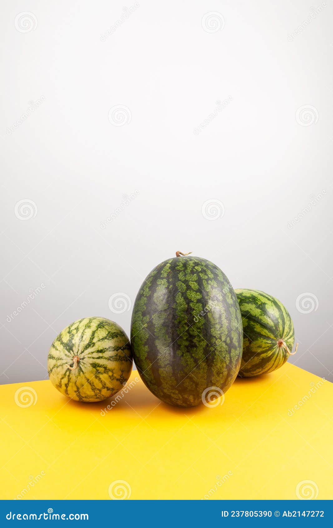 Mini Watermelons on Yellow Table. Three Ripe Watermelons of Different ...
