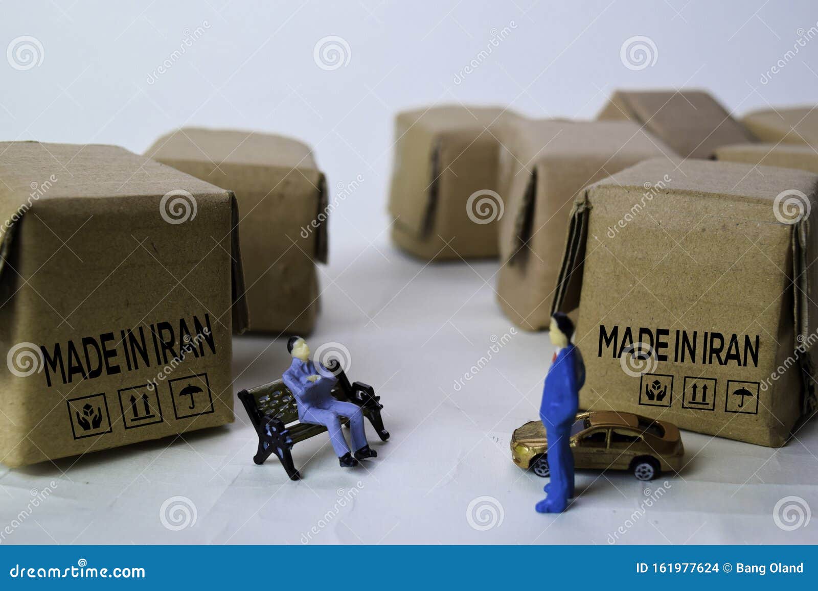 Miniature Businessman Talking in Front of Boxes with Text Made in Iran ...
