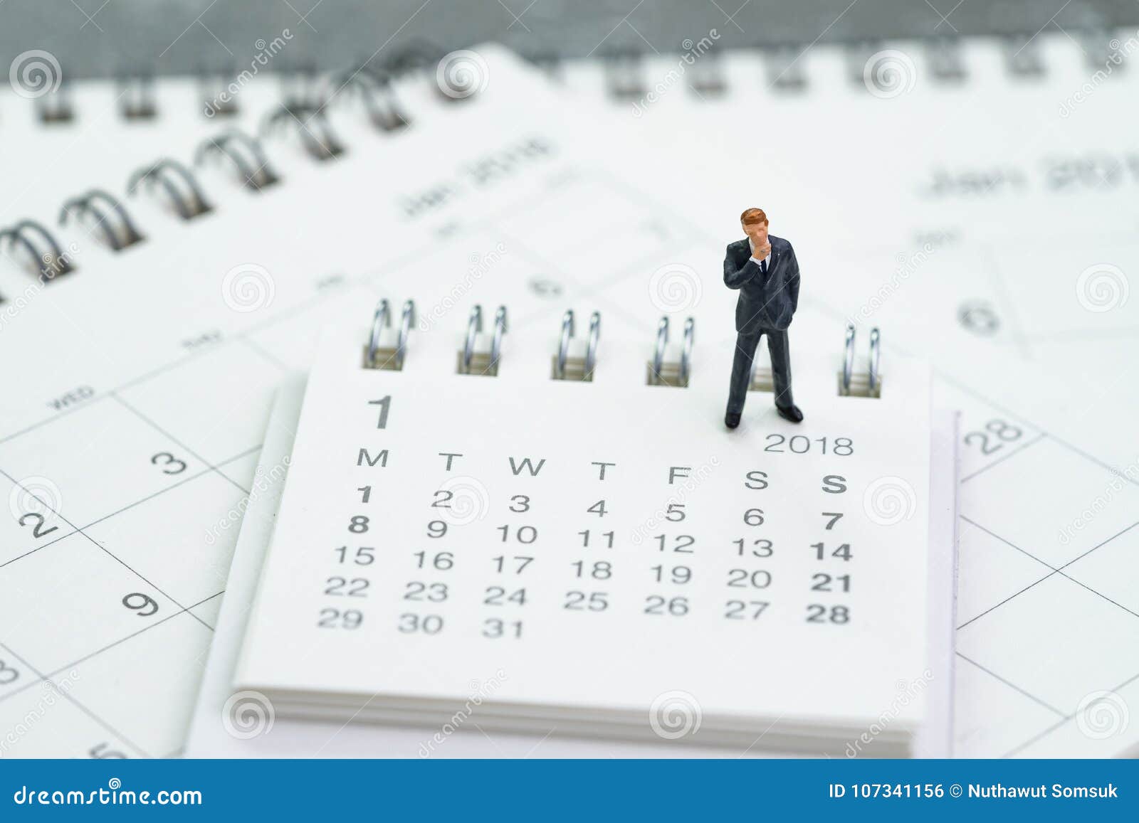 Miniature Businessman Thinking and Standing on Calendars Using a Stock ...
