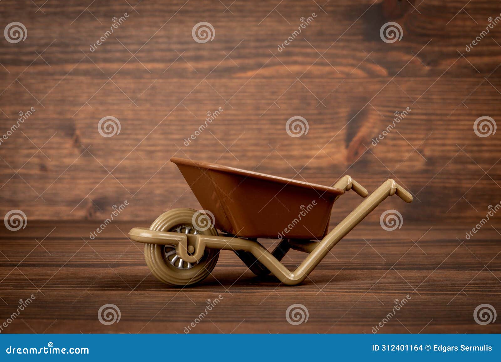 Miniature Construction or Garden Wheelbarrow on Wood Texture Background ...