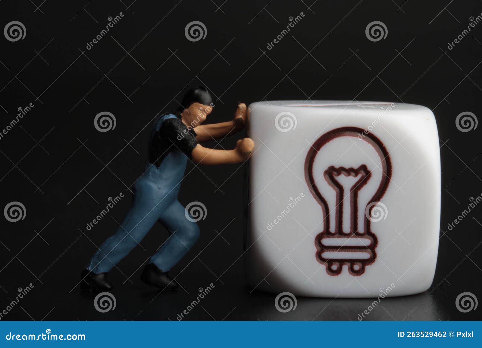 Miniature Figurine of a Man Pushing the Symbol of Idea Stock Photo ...