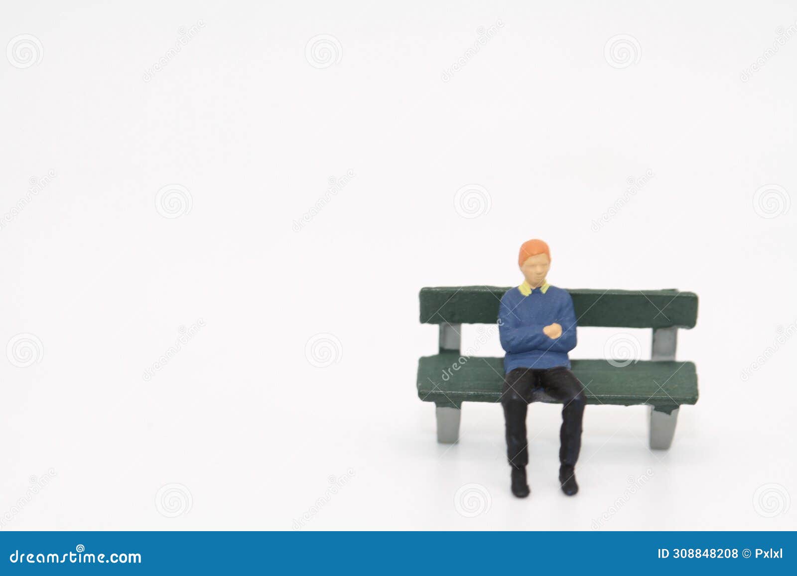 Miniature Figurine of a Man Sitting on a Bench Stock Photo - Image of ...