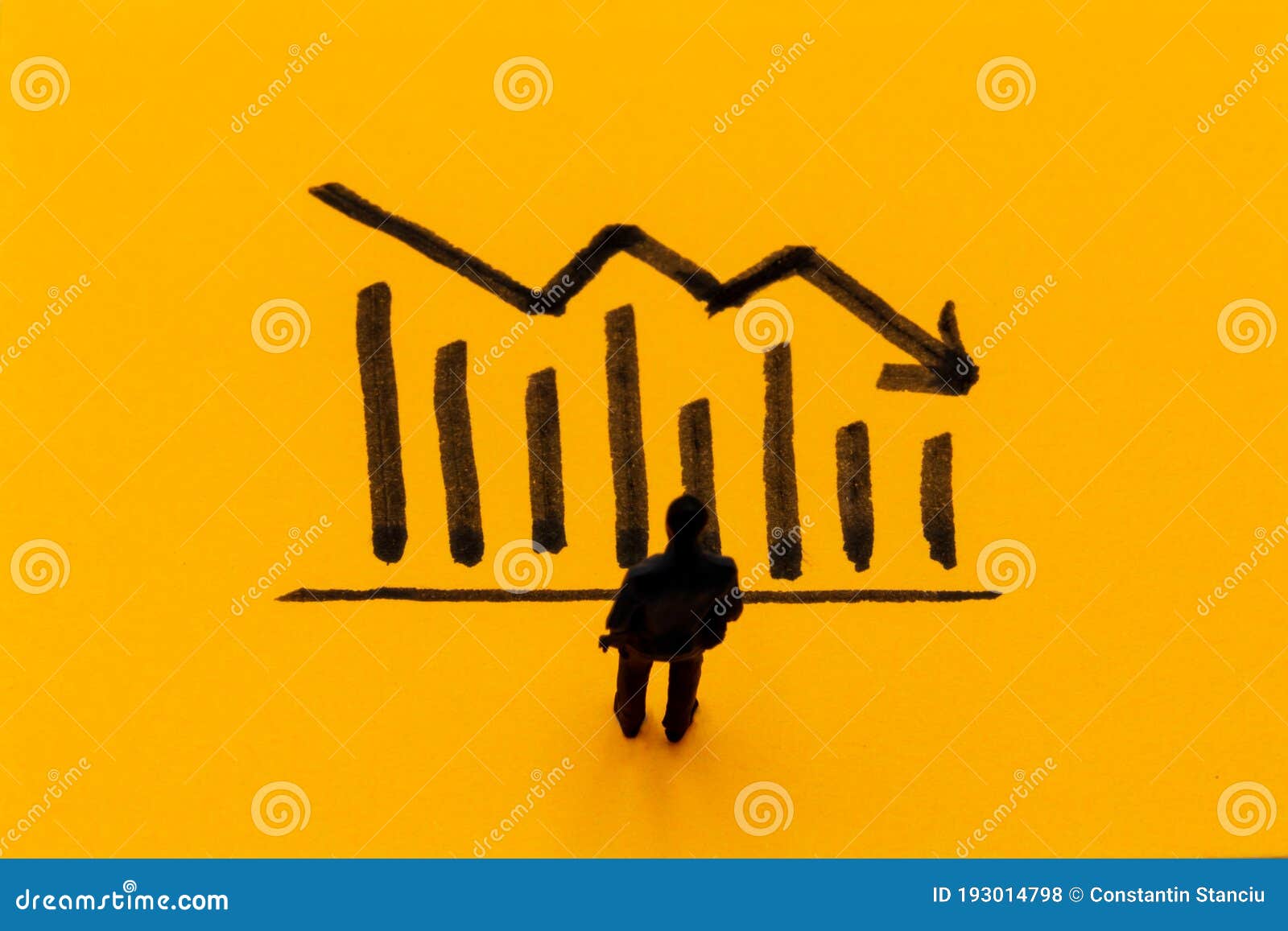 Miniature Figurine Posed As Businessman in Front of Descending Graph ...