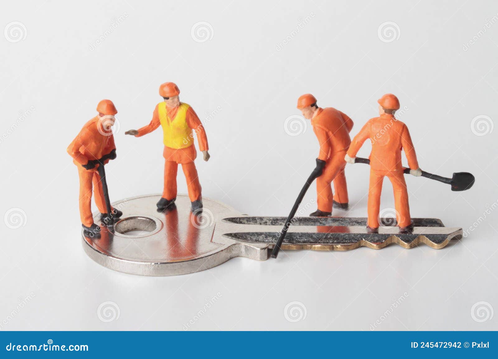 Miniature Figurines of Men at Work with a Giant Key Stock Photo - Image ...