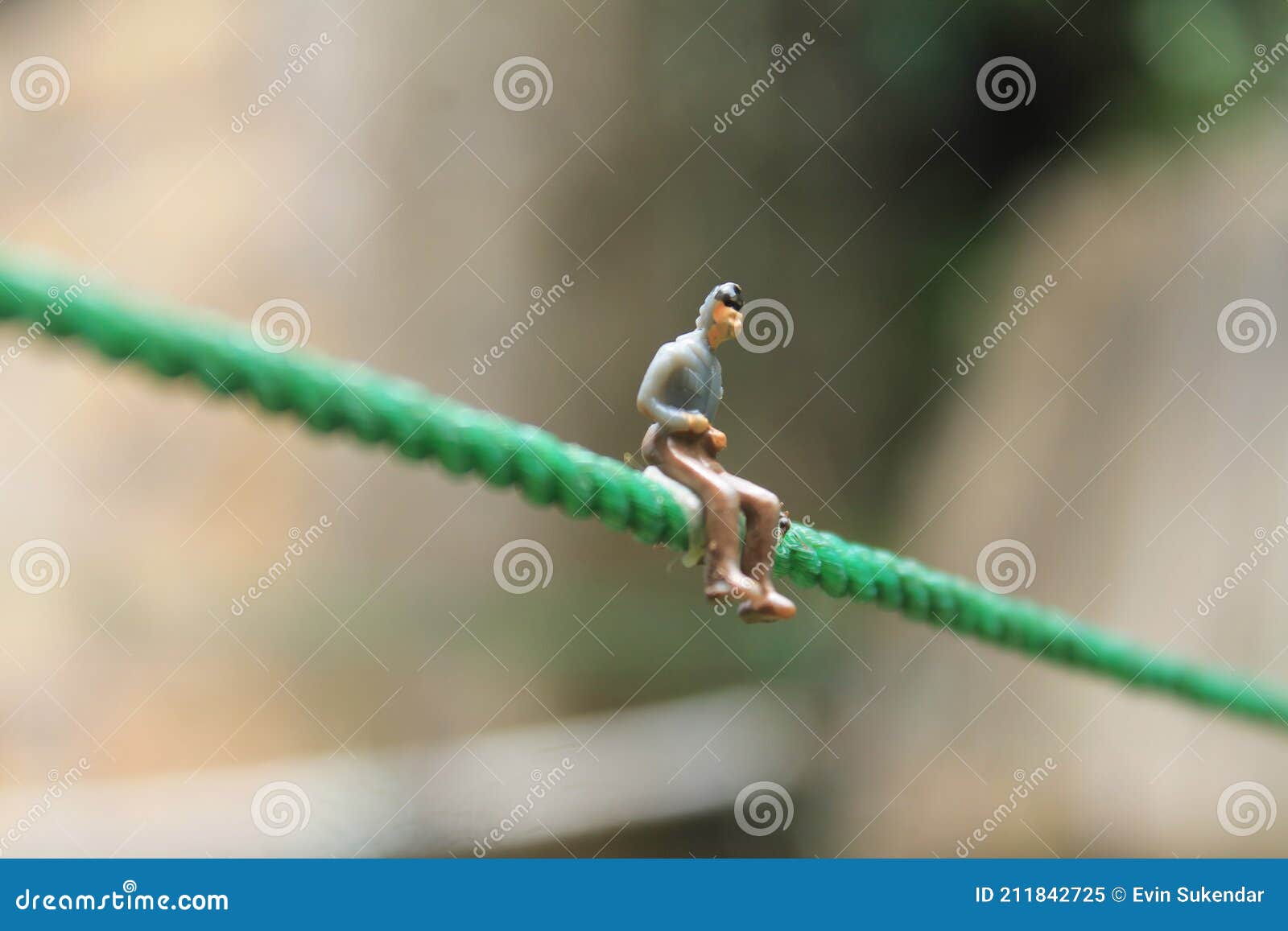 Miniature of a Man Sitting on a Rope Stock Image - Image of bridge ...