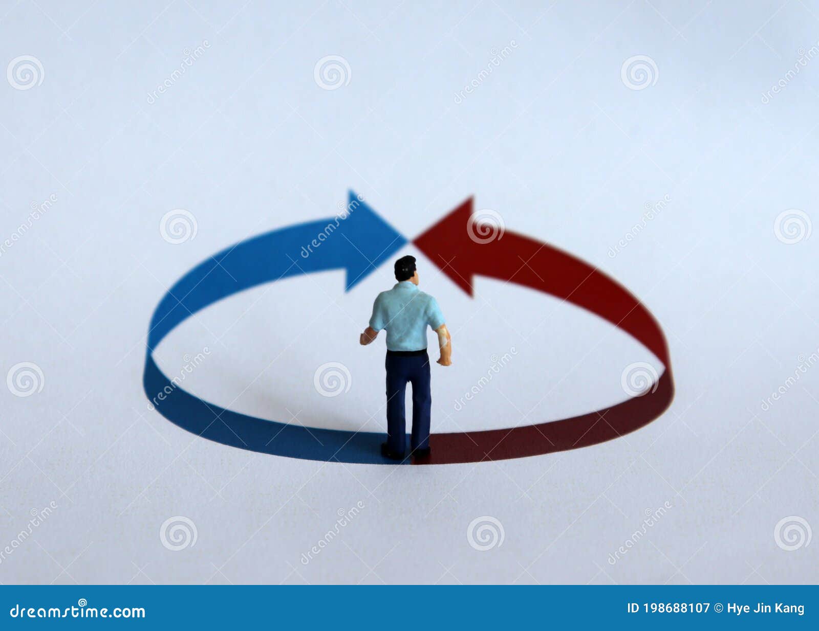 A Miniature Man Standing in Front of a Round Circle with an Arrow ...