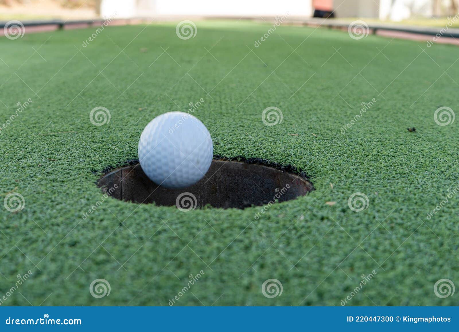 Miniature or Mini Golf Hole with Ball Falling into the Hole on Green ...
