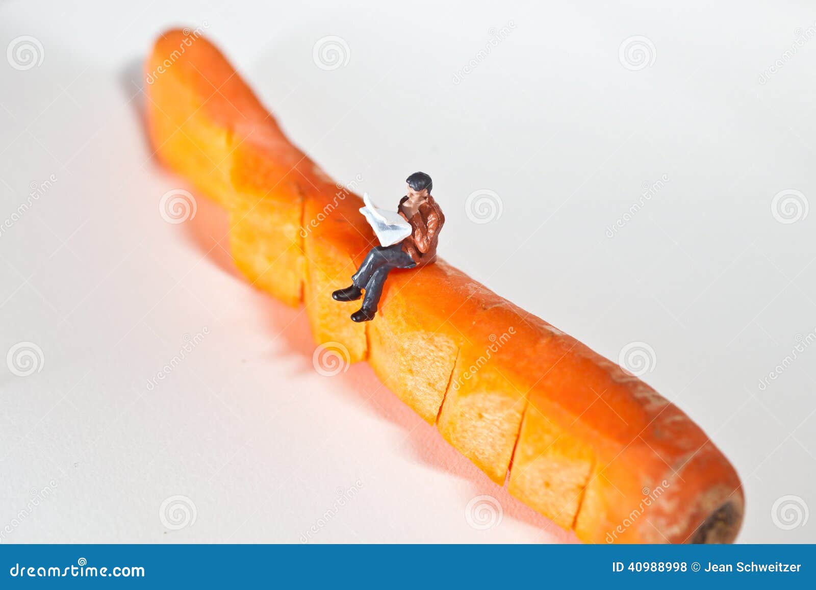 Miniature People in Action Sitting on a Carrot Stock Photo - Image of ...