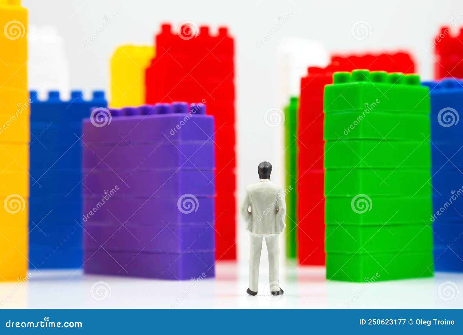 Miniature People. Figures of People Stand Near the Colored Blocks of a ...