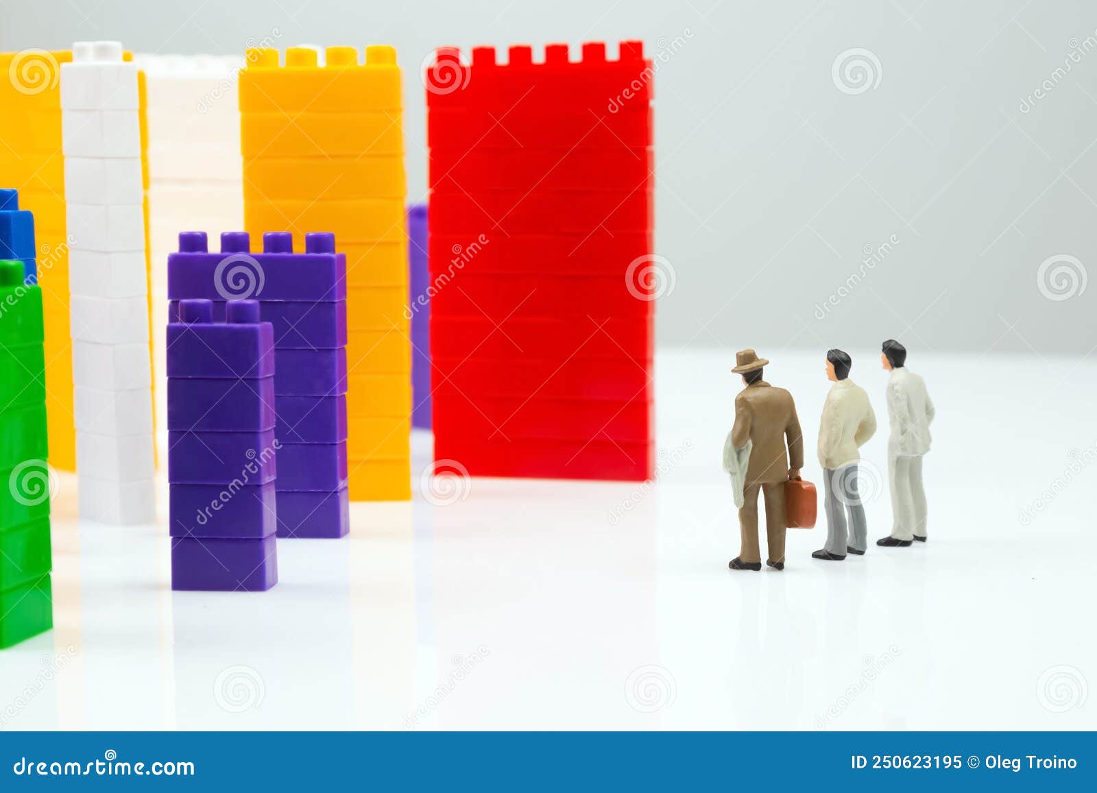 Miniature People. Figures of People Stand Near the Colored Blocks of a ...