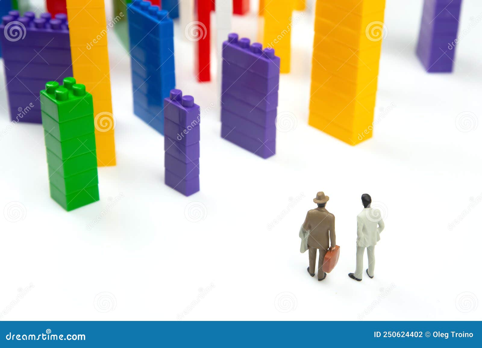 Miniature People. Figures of People Stand Near the Colored Blocks of a ...