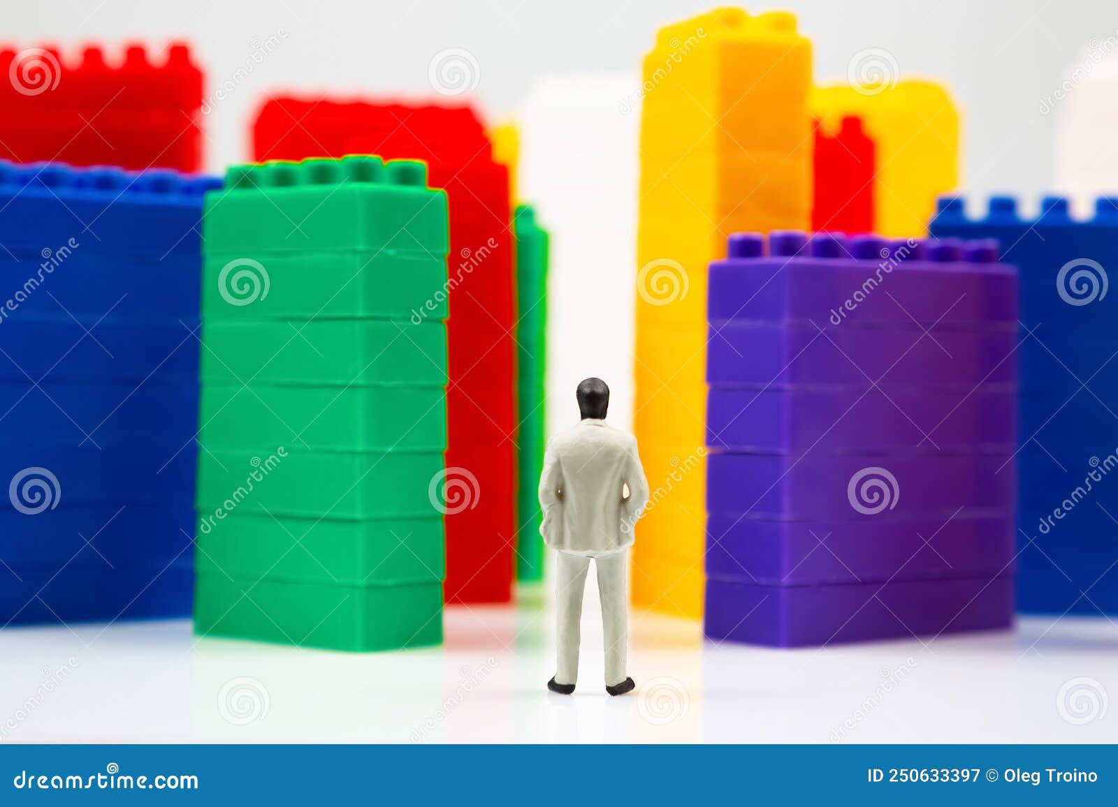 Miniature People. Figures of People Stand Near the Colored Blocks of a ...