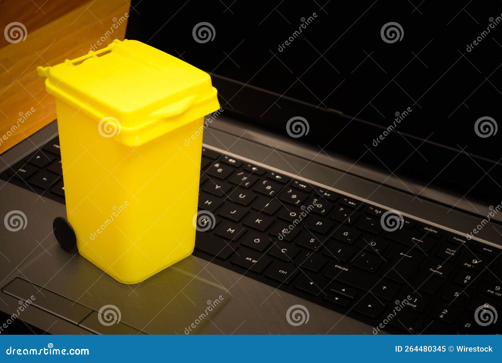 Miniature Yellow Bin on a Laptop Representing Electronic Waste Disposal ...