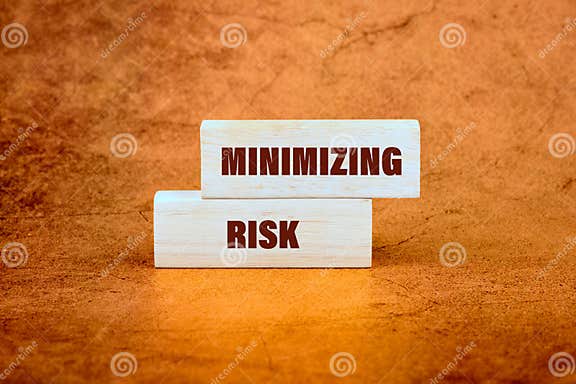 MINIMIZING RISK Text on Wooden Blocks on an Abstract Bright Background ...