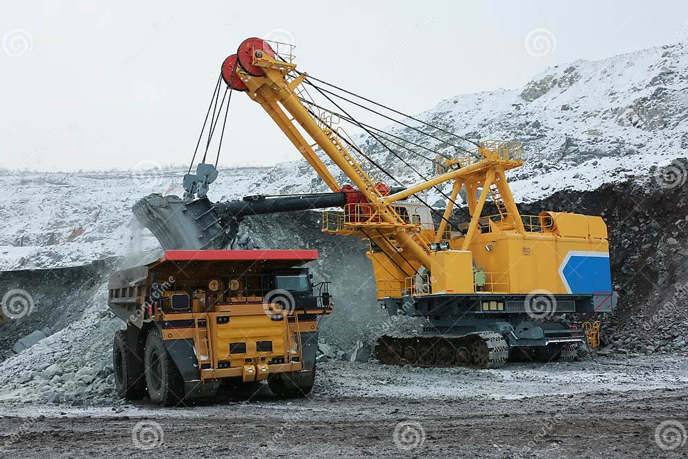 The Excavator is Loading a Yellow Mining Truck. Open Pit Mining. Stock ...