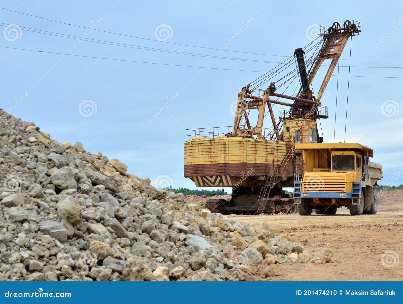 Mining Truck and Excavators Working in the Limestone Open-pit. Loading ...