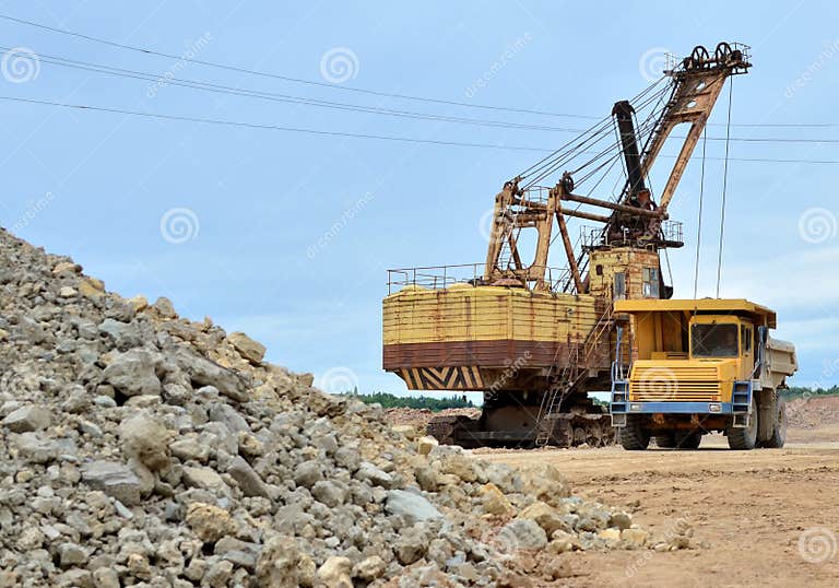 Mining Truck and Excavators Working in the Limestone Open-pit. Loading ...