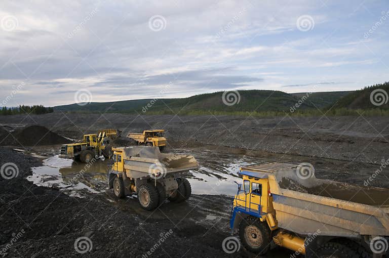 Mining Trucks are Queuing, in the Background a Wheel Loader is Loading ...