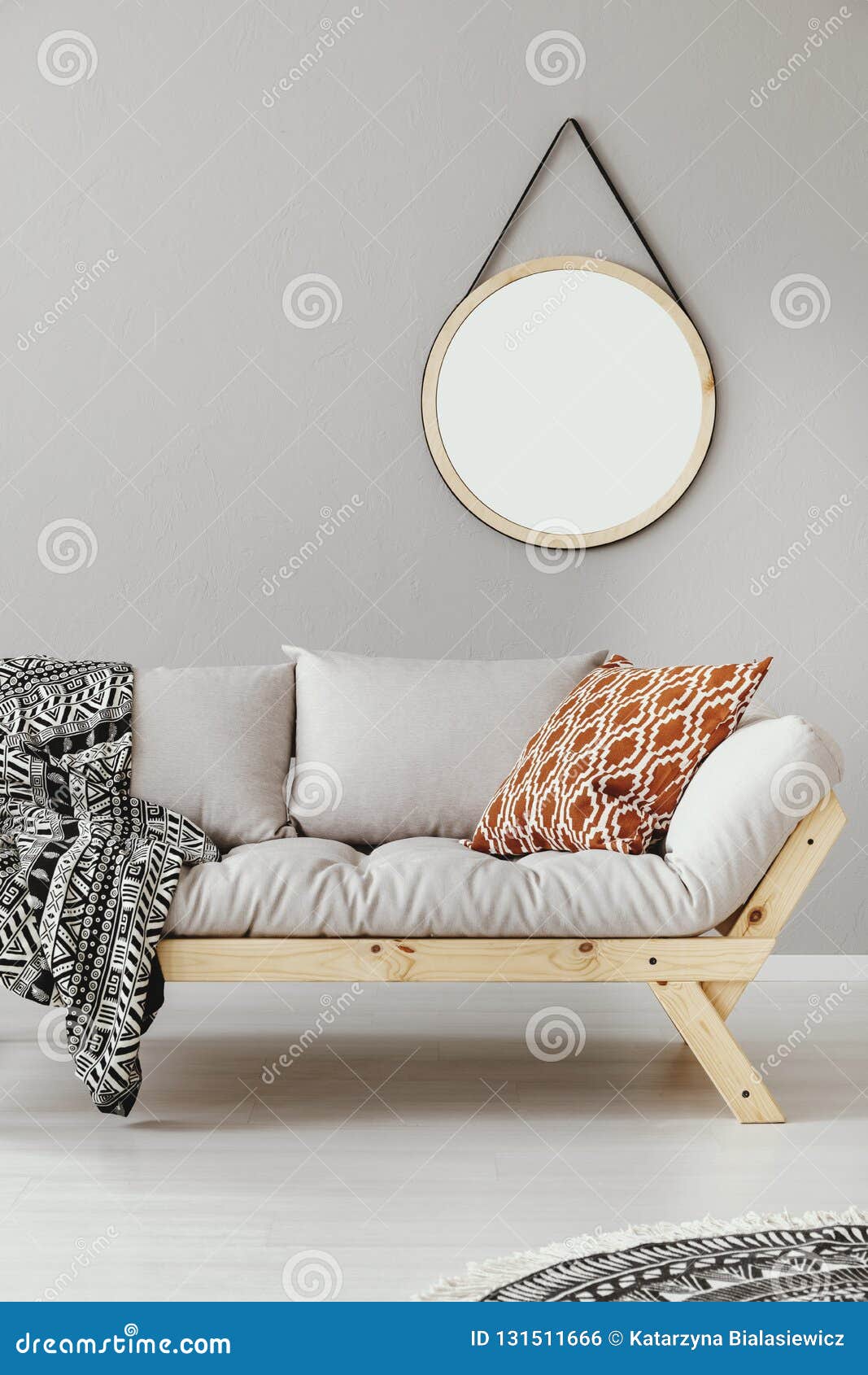 Mirror Above Scandinavian Settee with Patterned Pillow and Blanket ...
