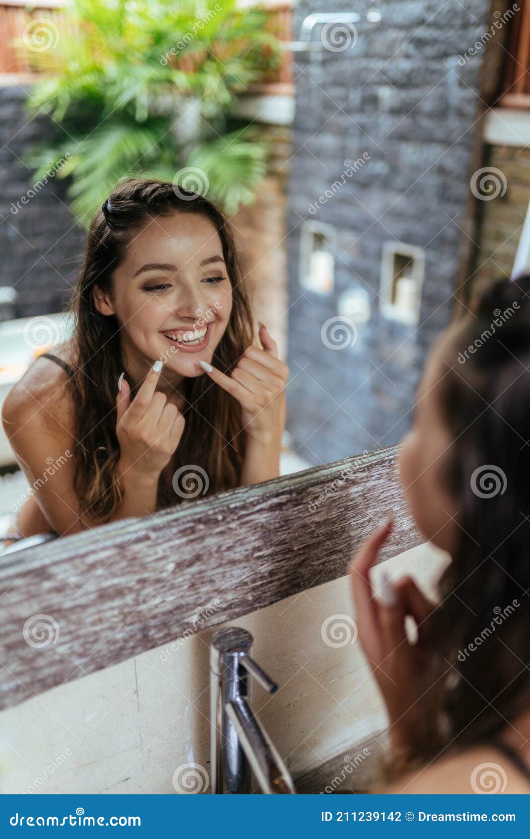 At The Mirror In The Bathroom Stands A Girl Squeezing On The Chin