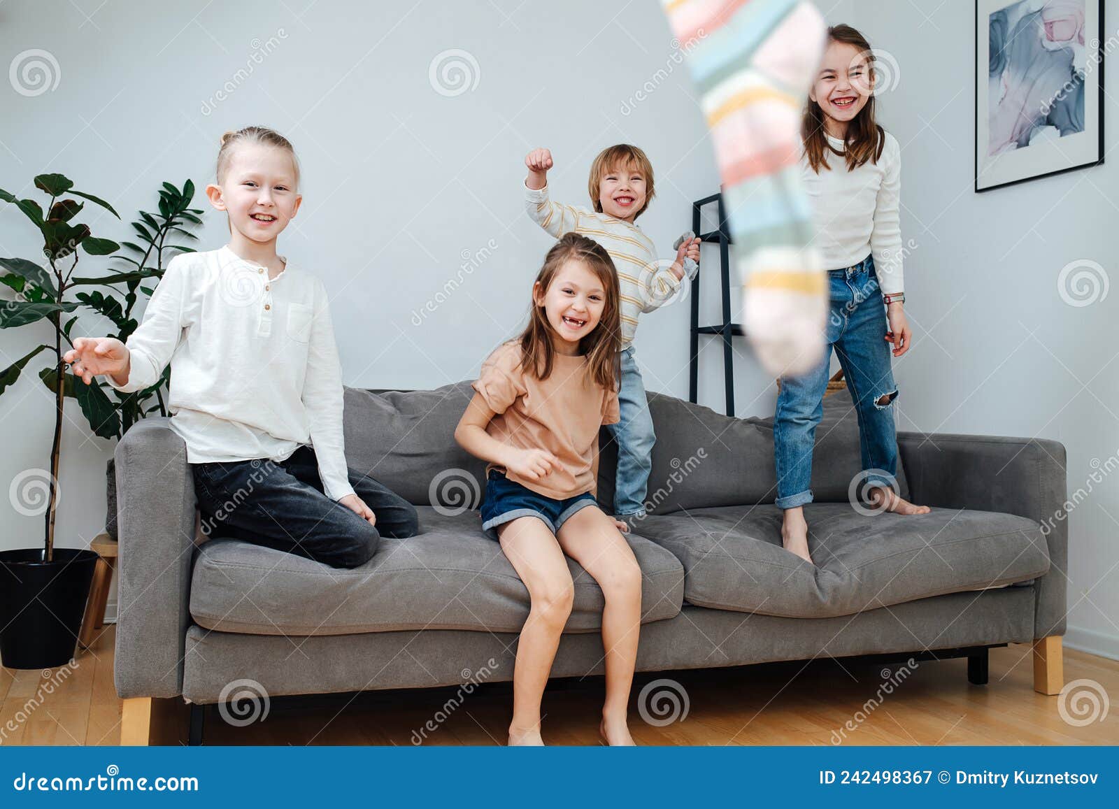 Mischievous Children Throwing Socks at the Camera, Jumping on a Couch ...