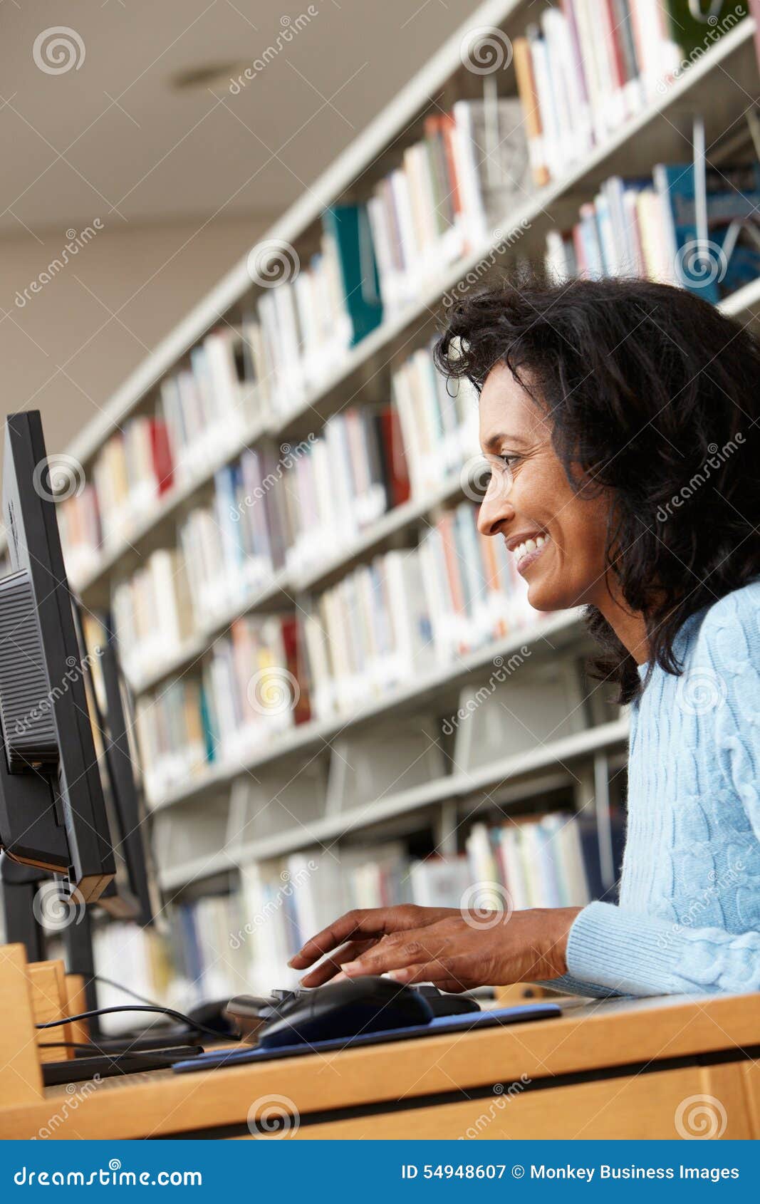 Mittlere Altersfrau, Die an Computer in Der Bibliothek Arbeitet ...