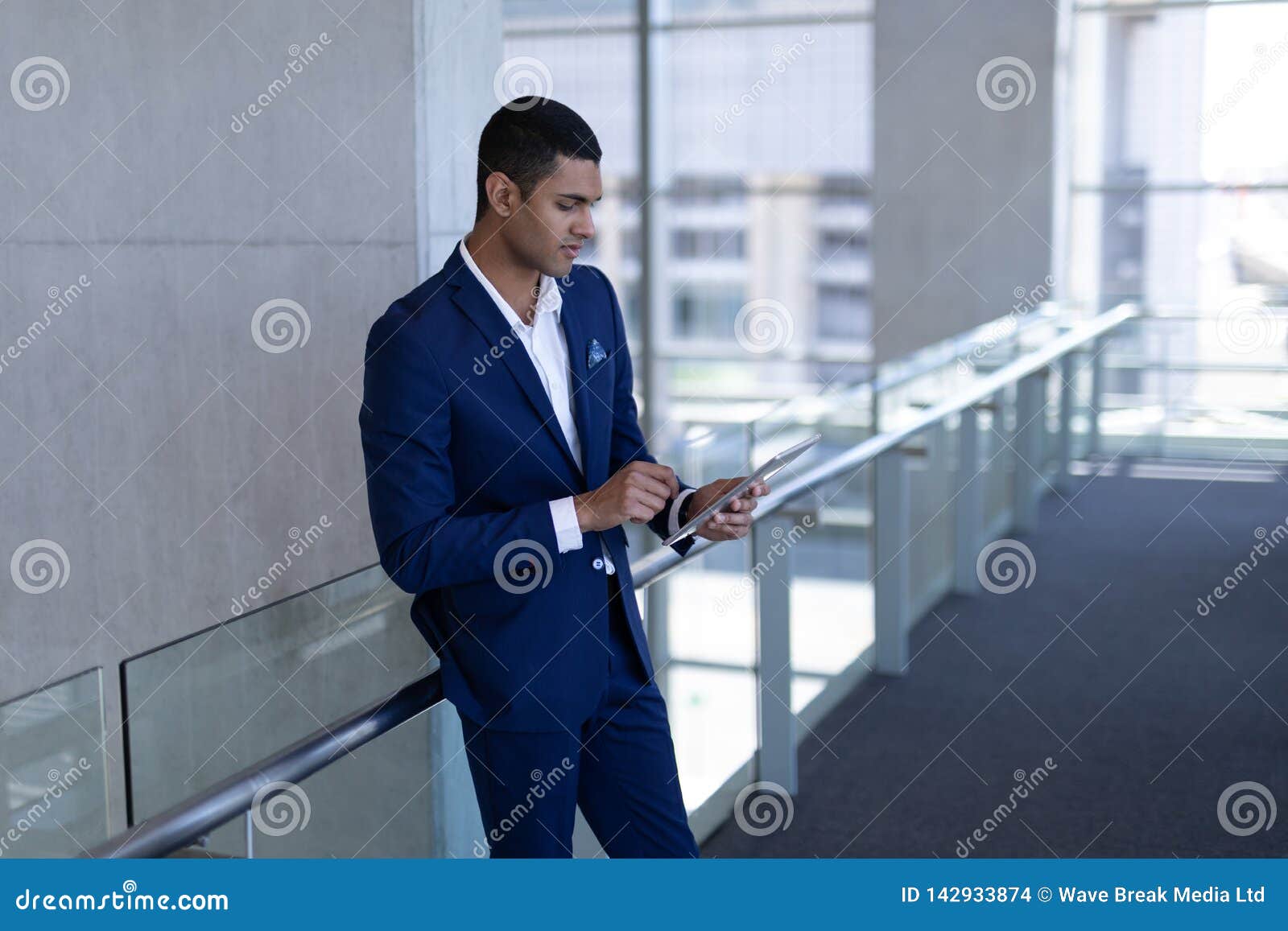 Mixed-race Businessman Using Digital Tablet in Modern Office Stock ...