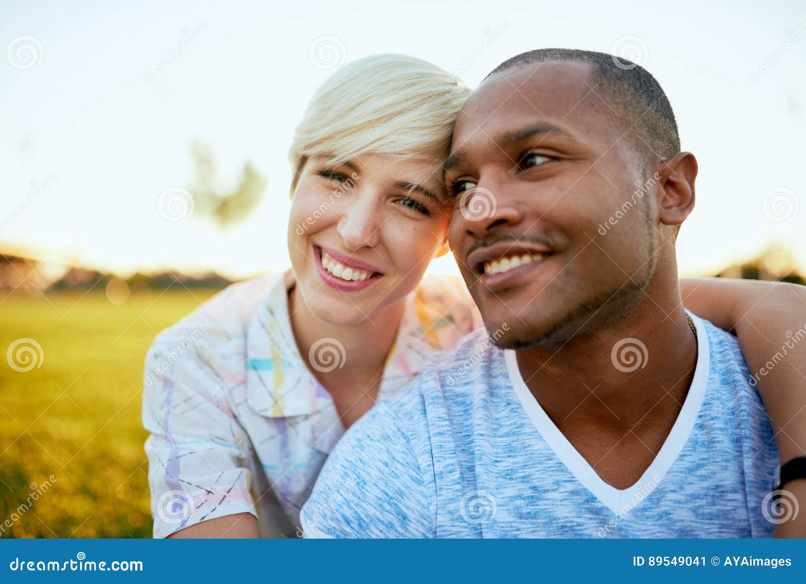 Mixed Race Couple of Millennial in a Grass Field Embracing for a Fun ... Mixed Race Couple of Millennial in a Grass Field Embracing for a Fun ...