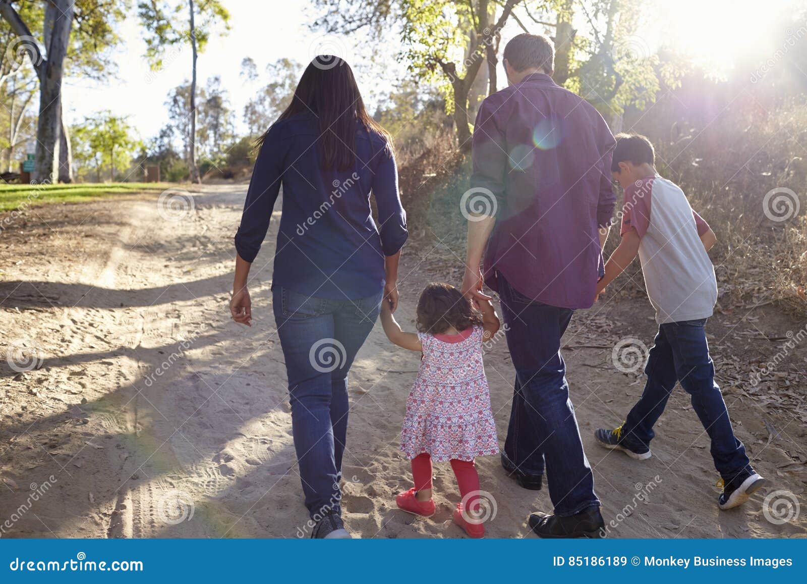 Mixed Race Family Walking on Rural Path, Backlit Back View Stock Image ...