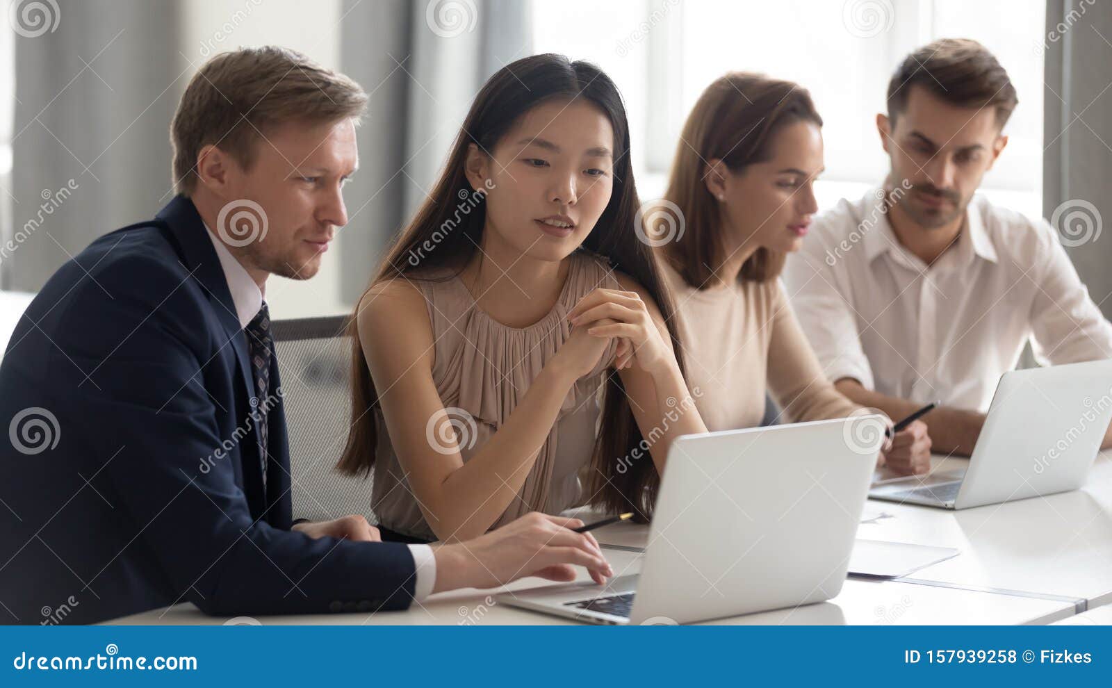 Mixed Race Groups of Employees Sitting at Shared Table, Working on ...