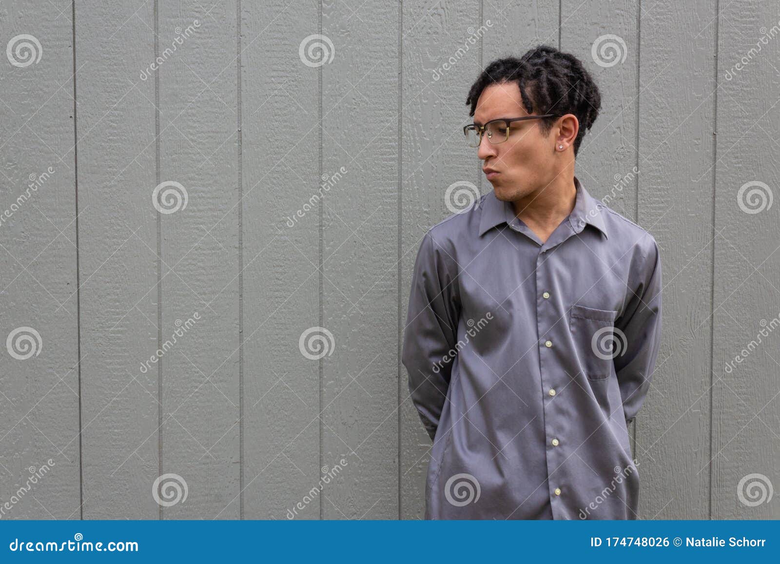 Mixed Race Millennial Man, Lips Pursed in Profile, Hands Behind Back ...